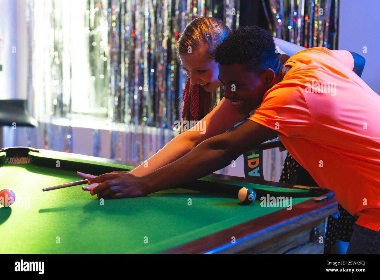 Teen diverse friends playing pool together, smiling and enjoying time ...