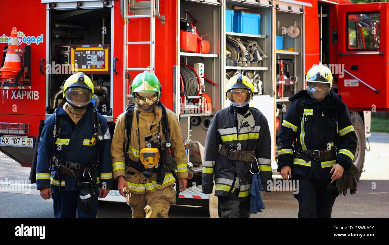 Portrait of male and female firefighters in helmets and protective ...