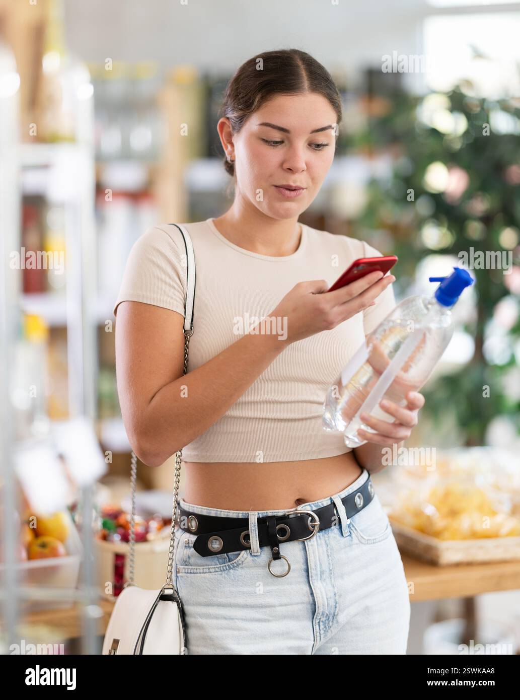 Young woman scanning qr code of soda Stock Photo - Alamy