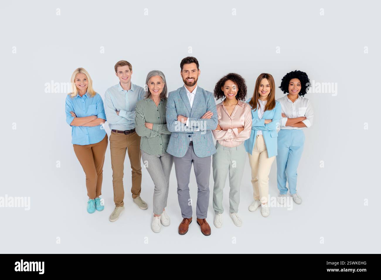 Group of diverse professionals standing together confidently against a ...