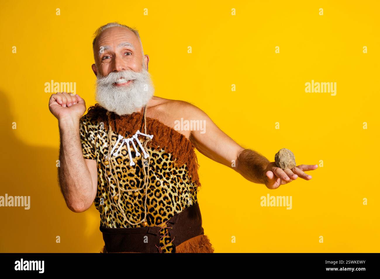 Photo of ancient aged caveman show rock raise fist wear leopard skin ...