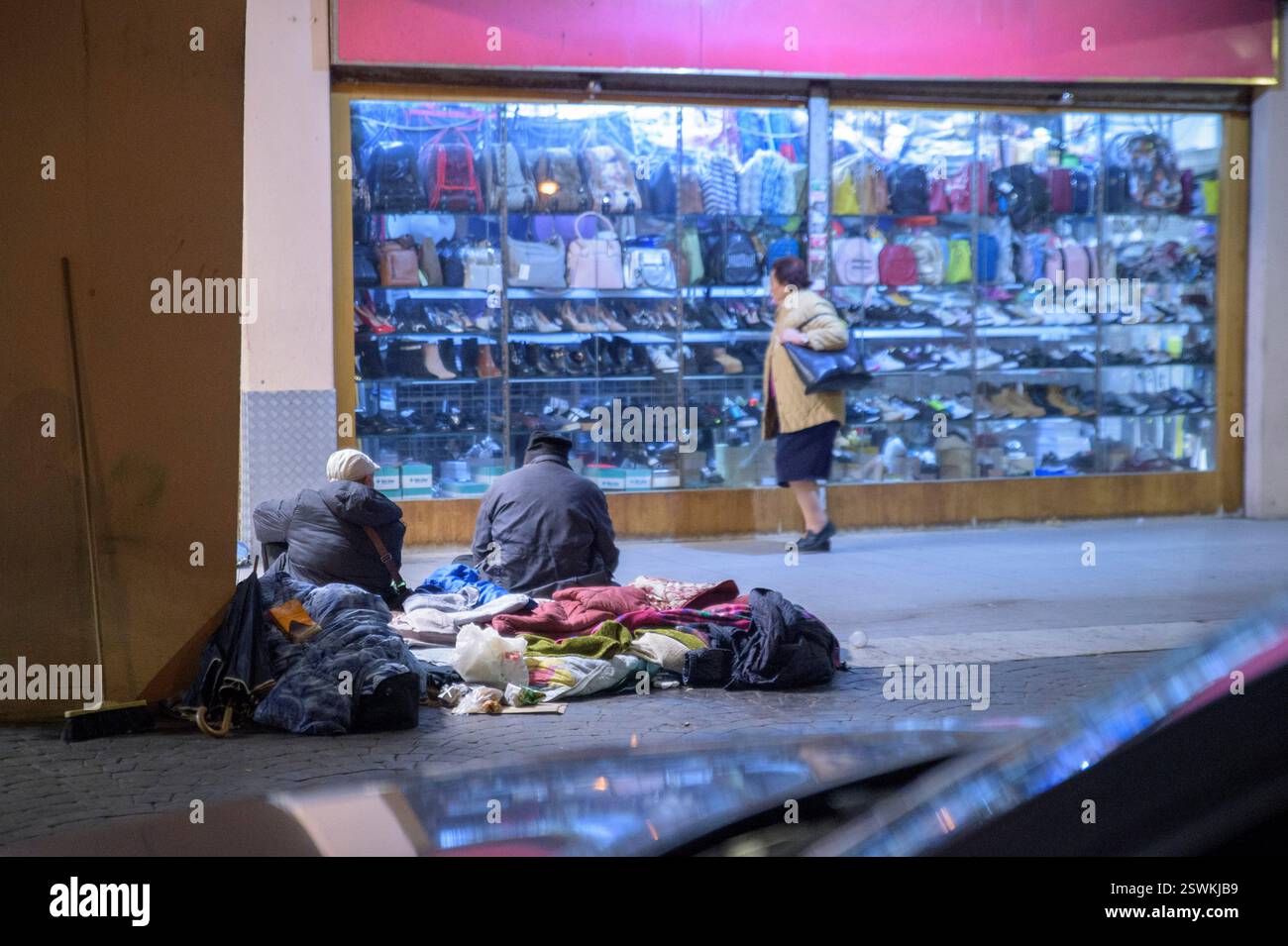 Rome, Italy. 21st Feb, 2025. Two homeless people talk while sitting on ...