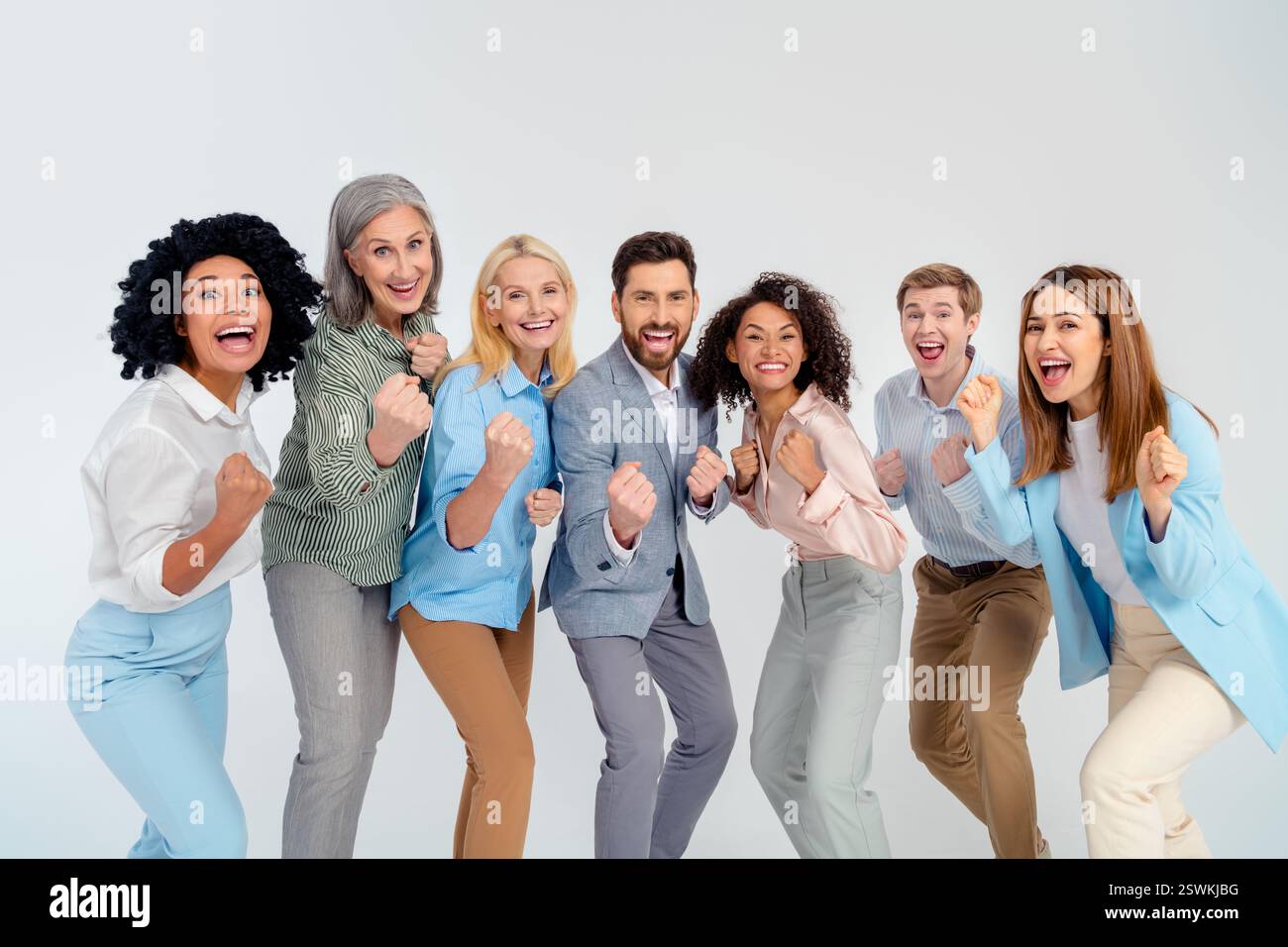 Diverse group of smiling coworkers in formal attire showcasing teamwork ...