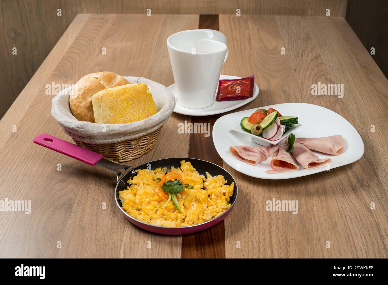 Breakfast spread with scrambled eggs bread ham and a side salad on a ...