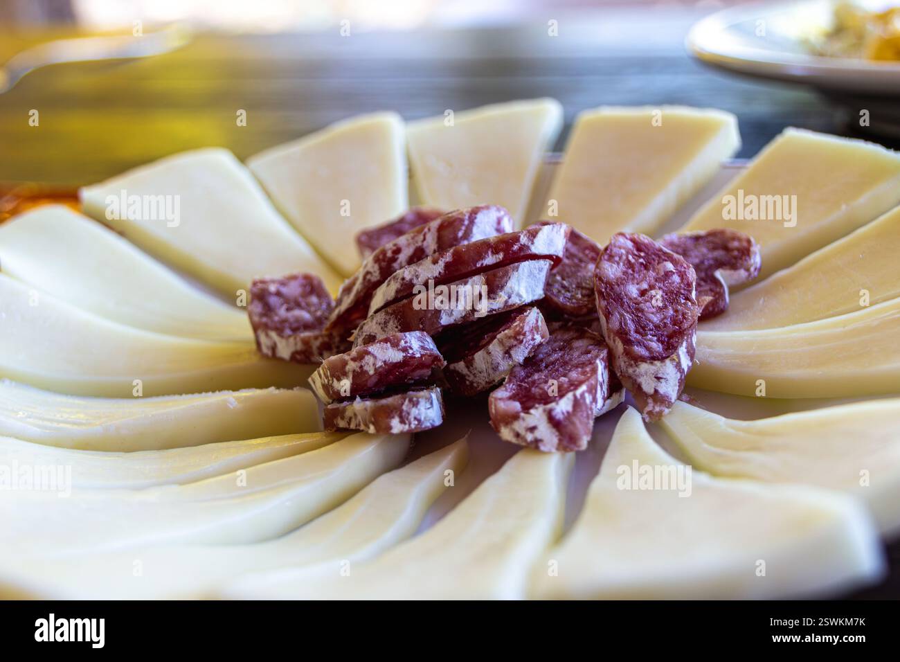 A plate filled with slices of cured meat, fuet, arranged in a circular ...
