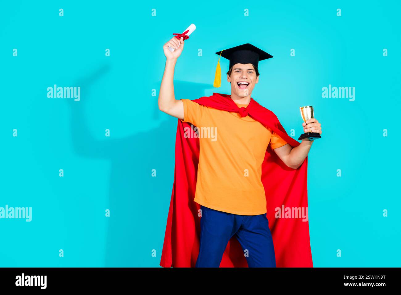 Cheerful male graduate holding trophy and certificate against vibrant ...