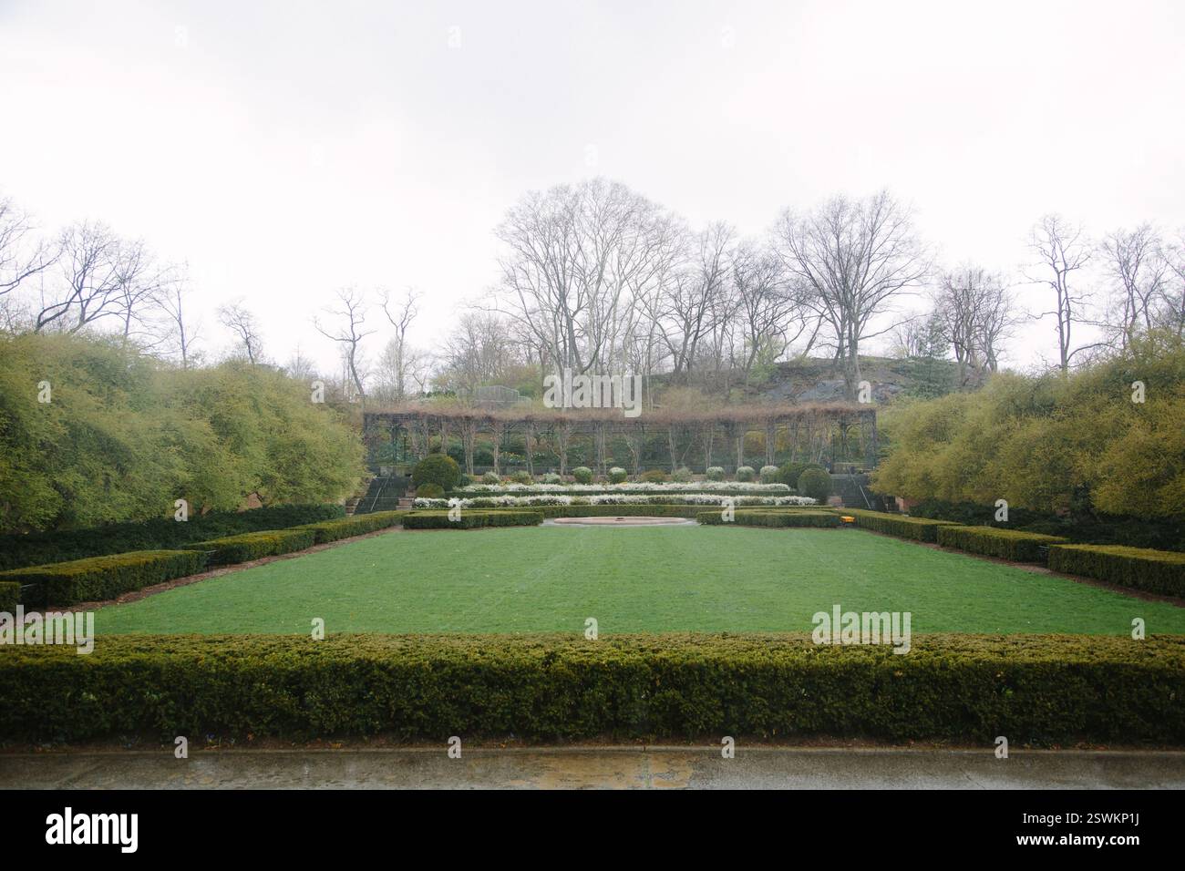 Garden features neatly arranged hedges and vibrant greenery under an ...