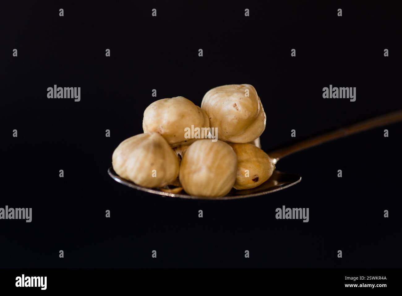 Natural nuts in a spoon on a contrasting background Stock Photo - Alamy