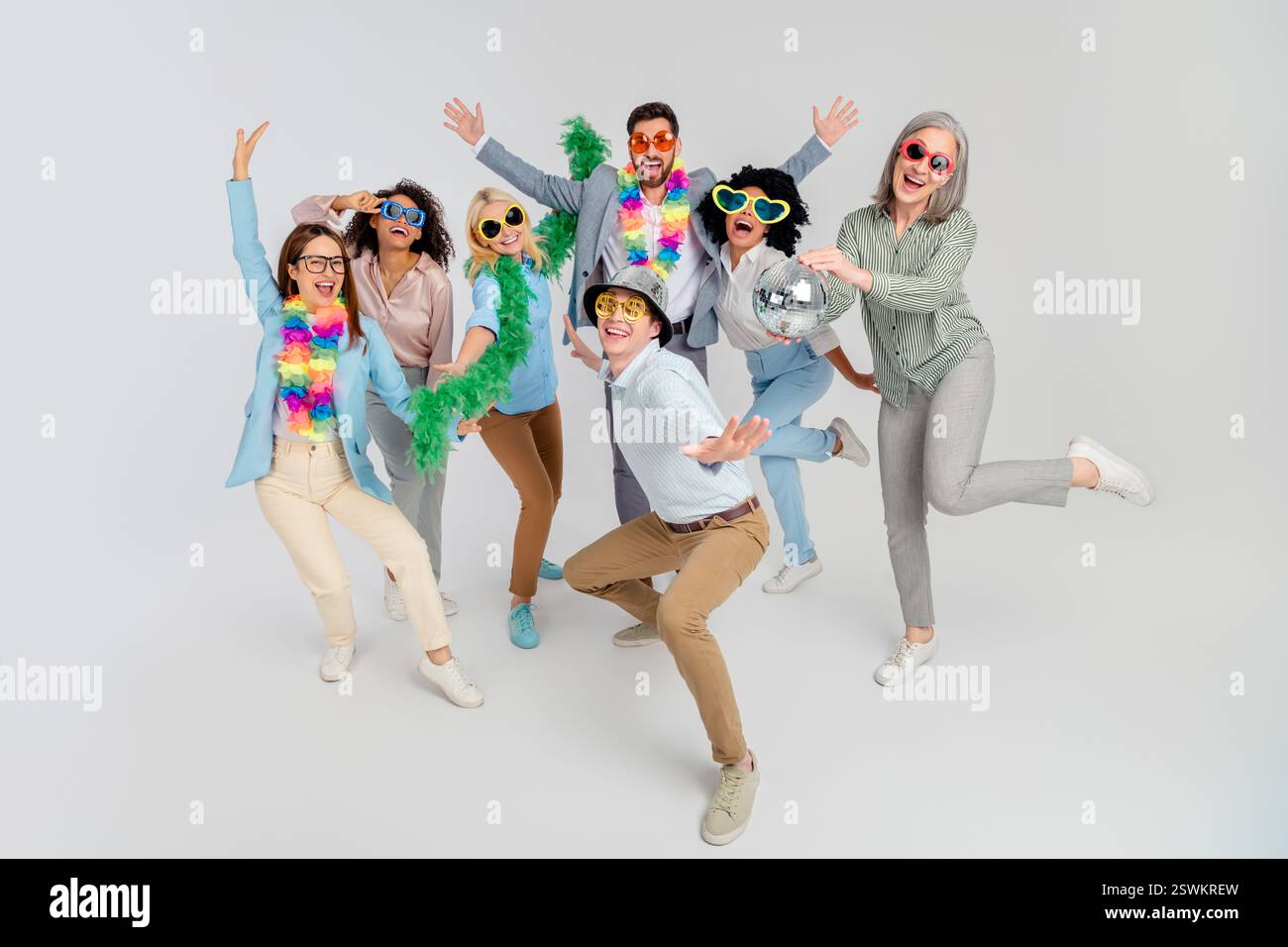 Diverse Team Celebrating Joyfully with Colorful Props on a Grey ...