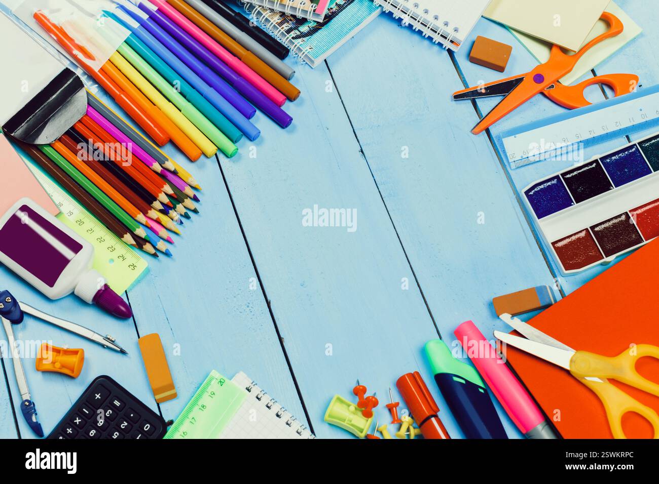 Brightly colored stationery supplies arranged on a turquoise wooden ...