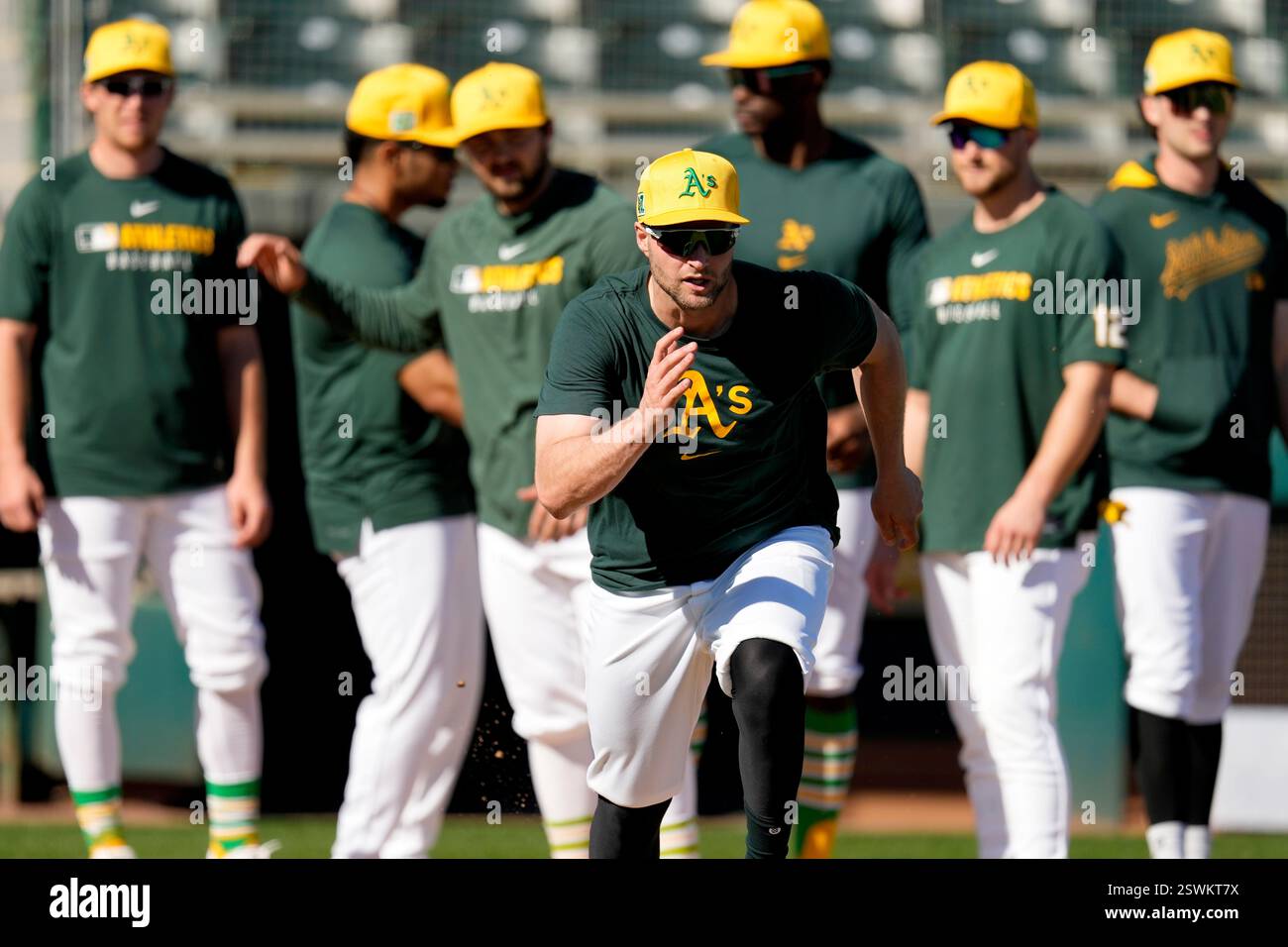 Athletics players run drills during a spring training baseball workout ...