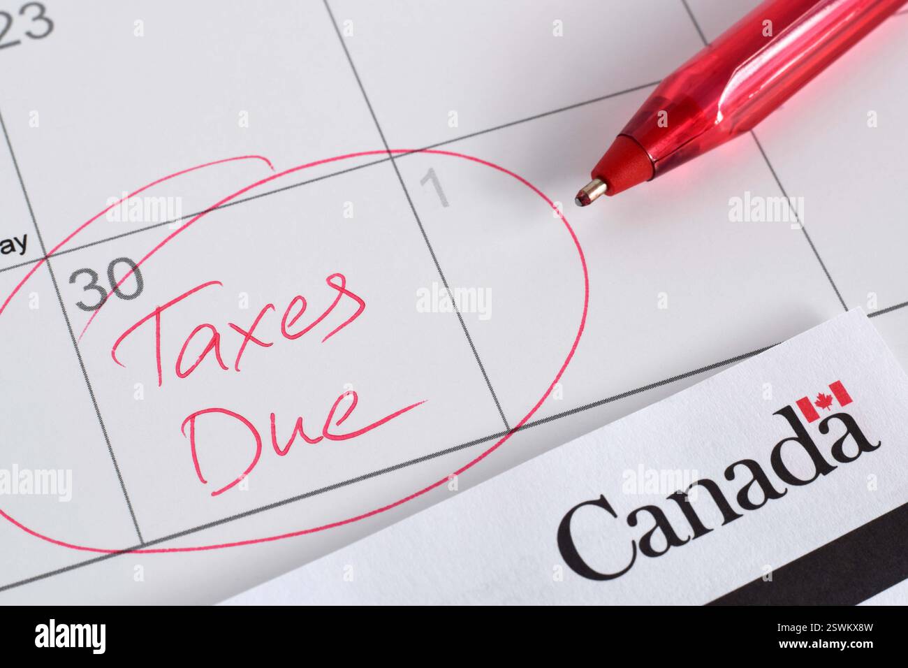 Closeup calendar with circled April 30 date with words Taxes Due to ...