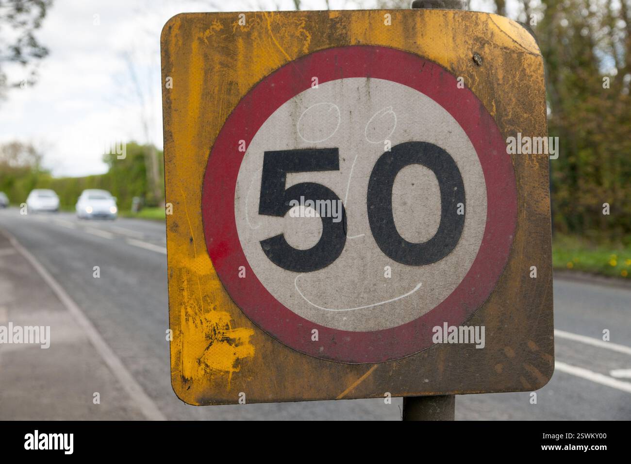 50 mph speed limit sign on a road near trees, likely in the UK Stock ...