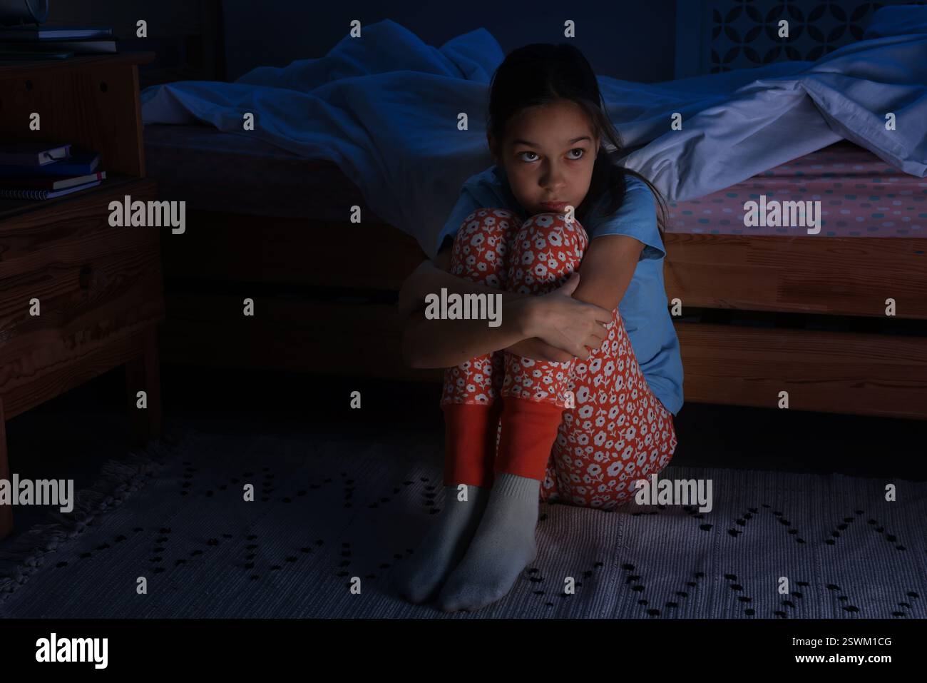 Afraid girl near bed in her room at night Stock Photo - Alamy