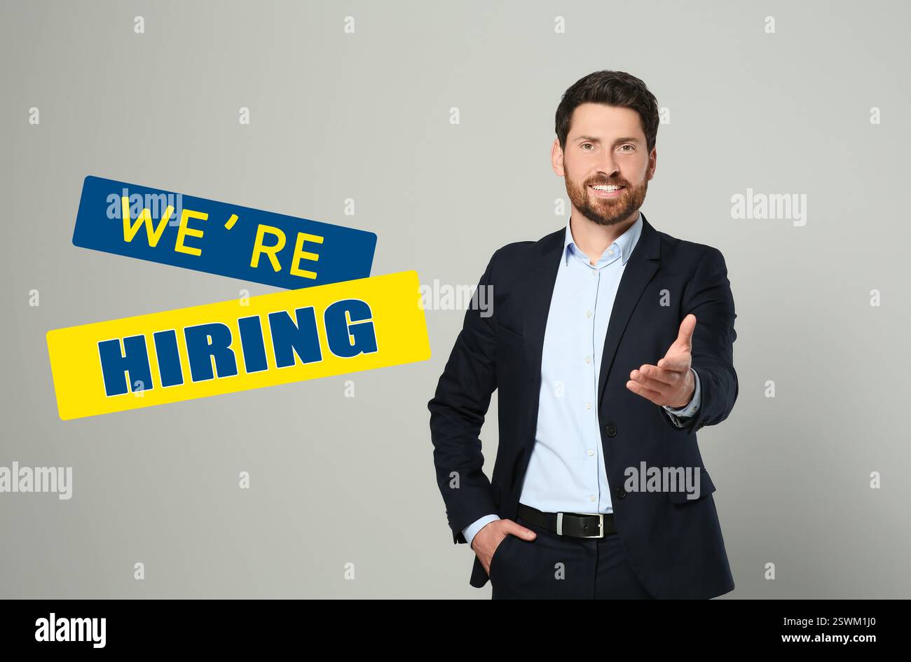 We're hiring. Handsome businessman on grey background. Human resource ...