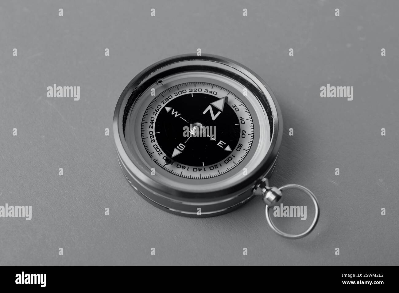 Compass on table, closeup. Toned in black-and-white Stock Photo - Alamy