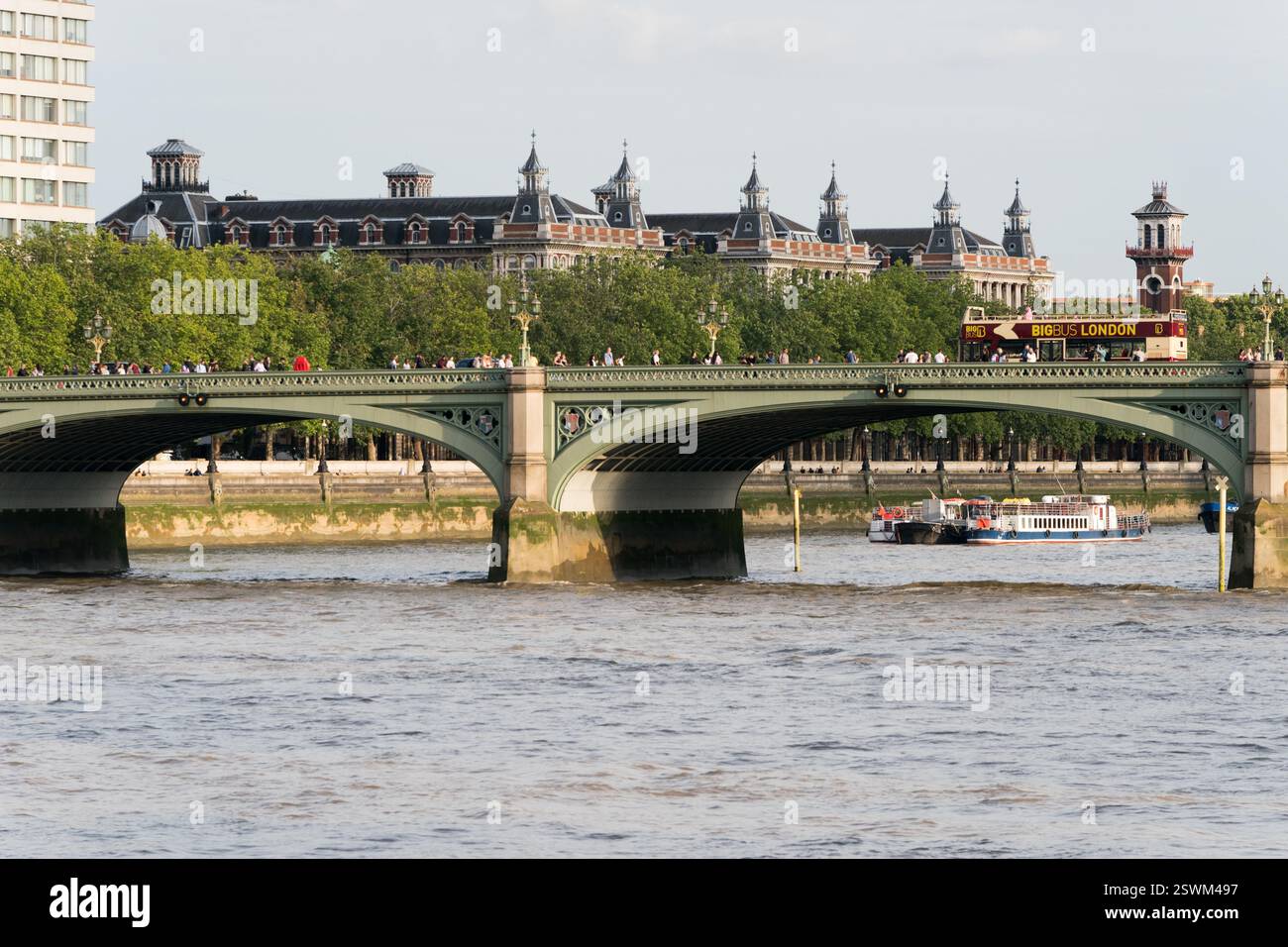 Pedestrians and a Big Bus London tour pass under Westminster Bridge and ...