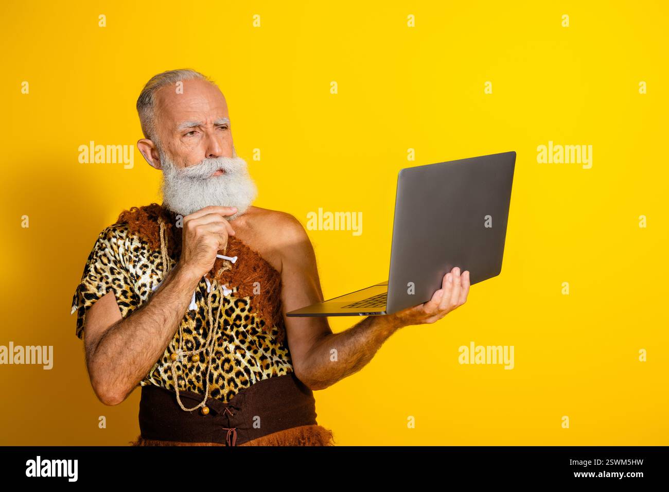 Photo of aged savage caveman ponder use laptop wear leopard skin outfit ...