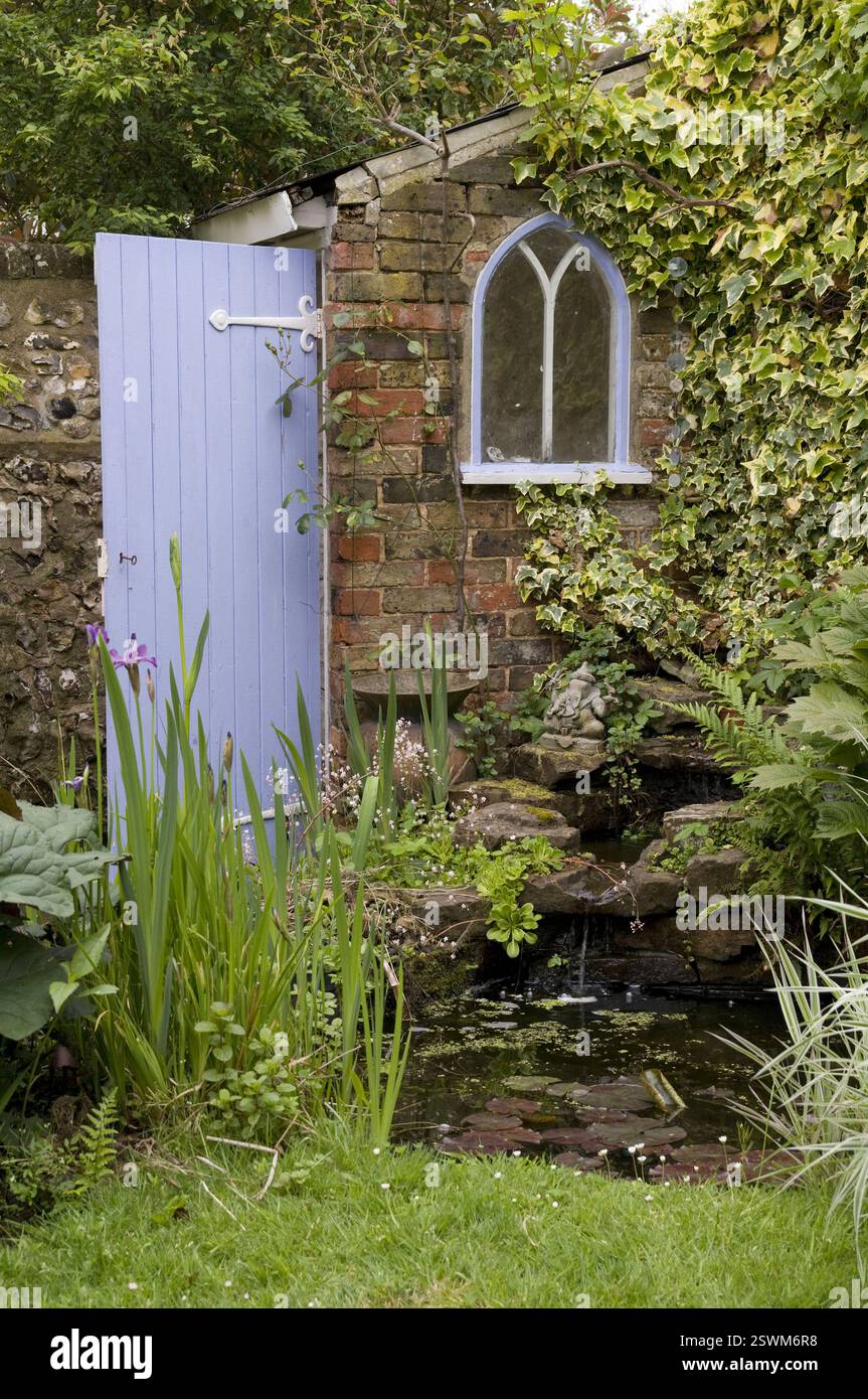 Garden pond in front of brick building with door ajar, Ditchling garden ...