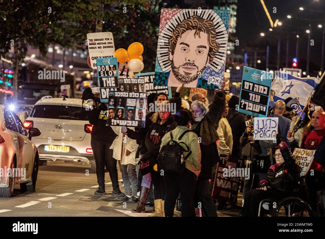 Protestors hold placards and a painting of Israeli hostage Alon Ohel ...