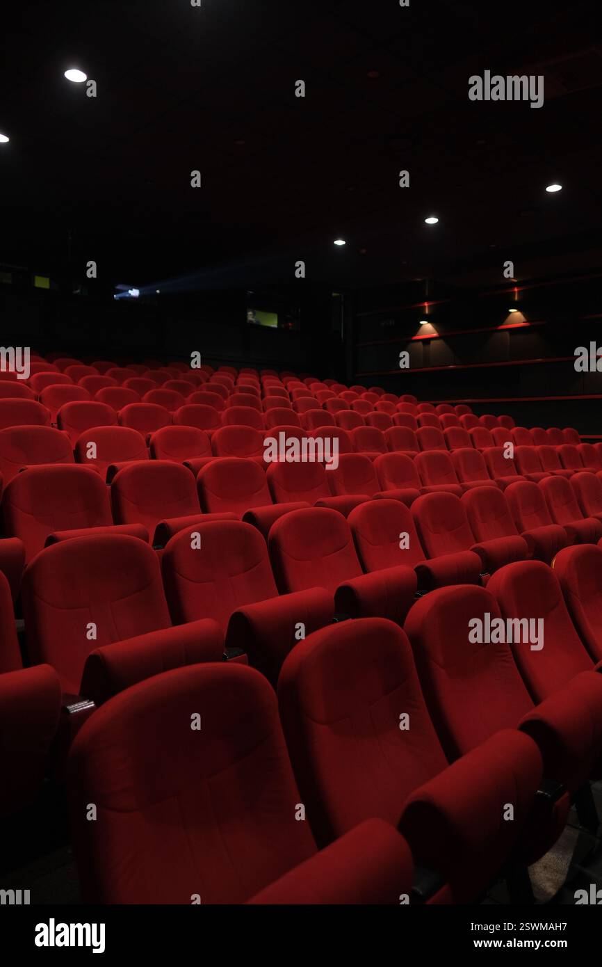 Rows of red seats in a darkened auditorium create a dramatic visual ...