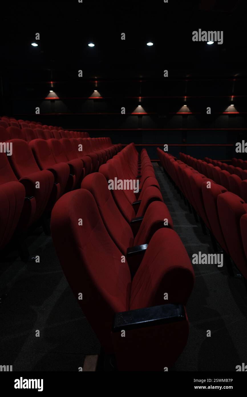 Rows of unoccupied red seats inside a theater awaiting the audience for ...