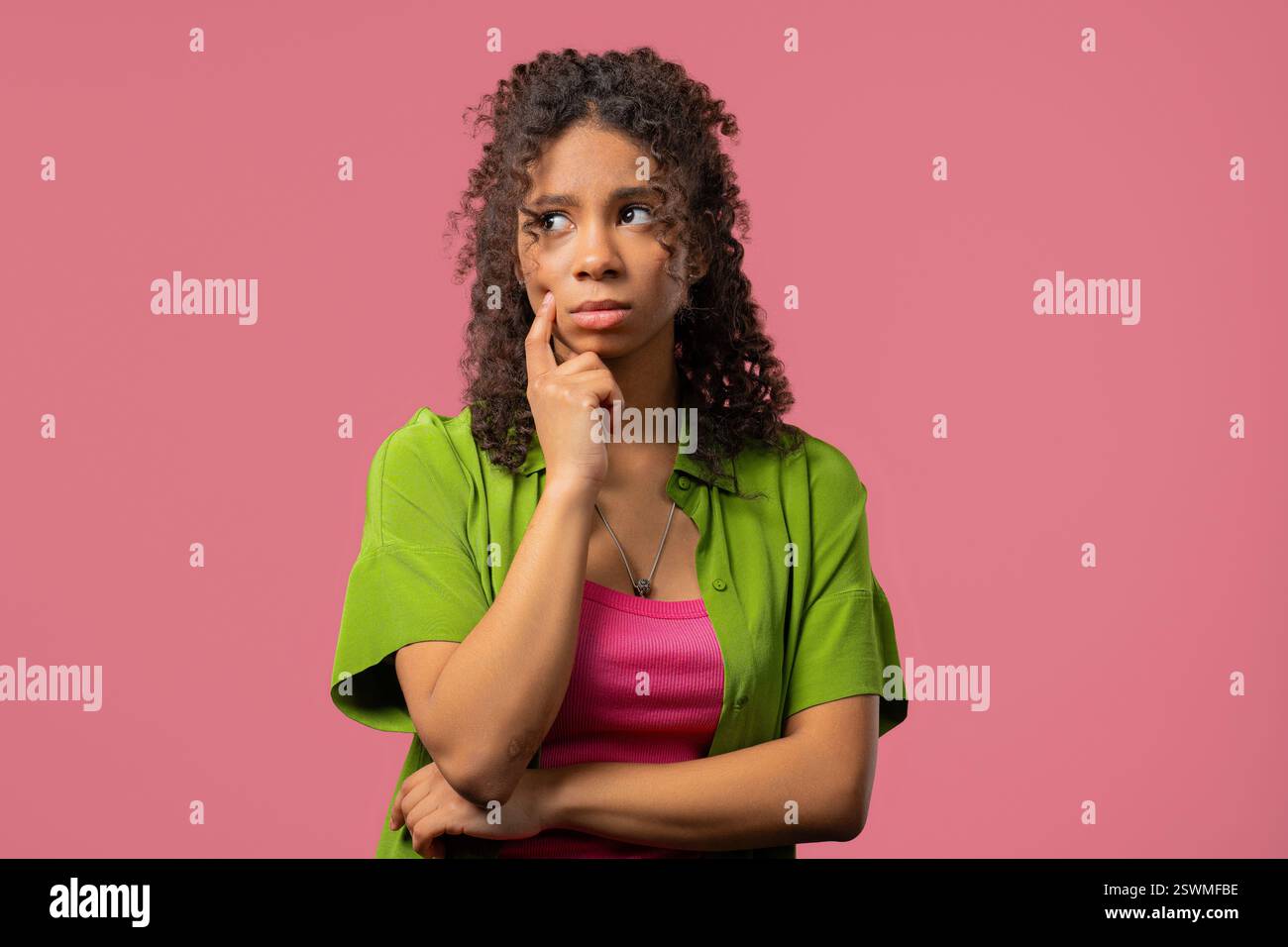 Thinking around african woman, Pink background.Puzzled teenager looking ...