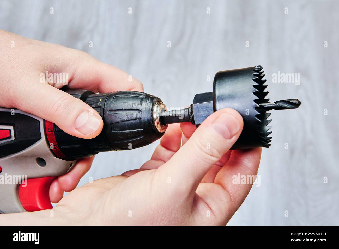 Hole saw attachment being fitted onto cordless drill Stock Photo - Alamy