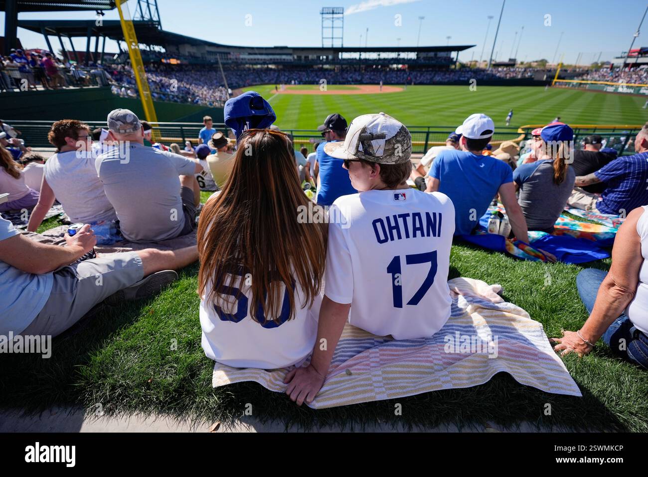 Fans watch from the outfield during the fourth inning of a spring ...