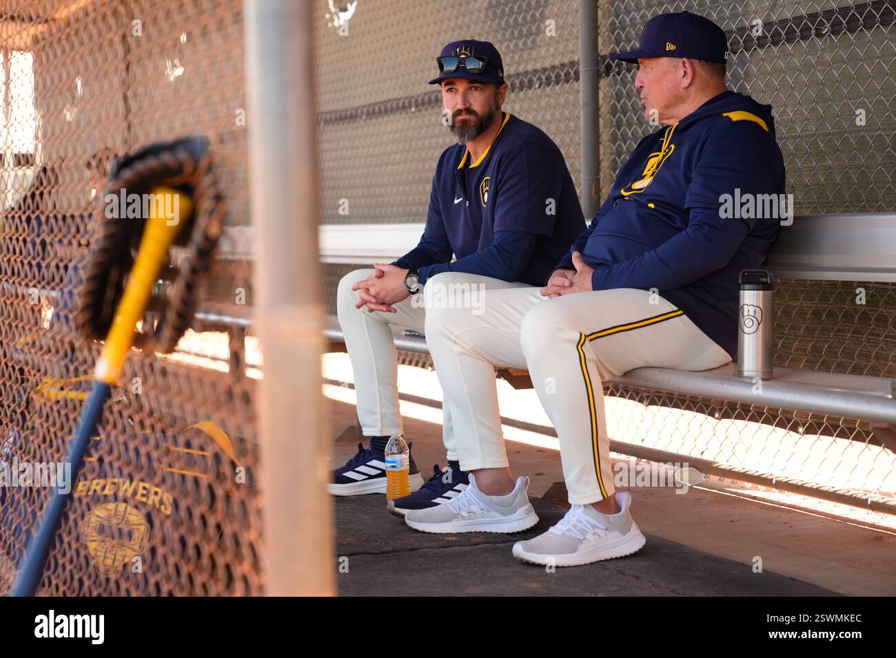 Milwaukee Brewers hitting coach Eric Theisen, left, talks with manager Pat Murphy in a dugout ...