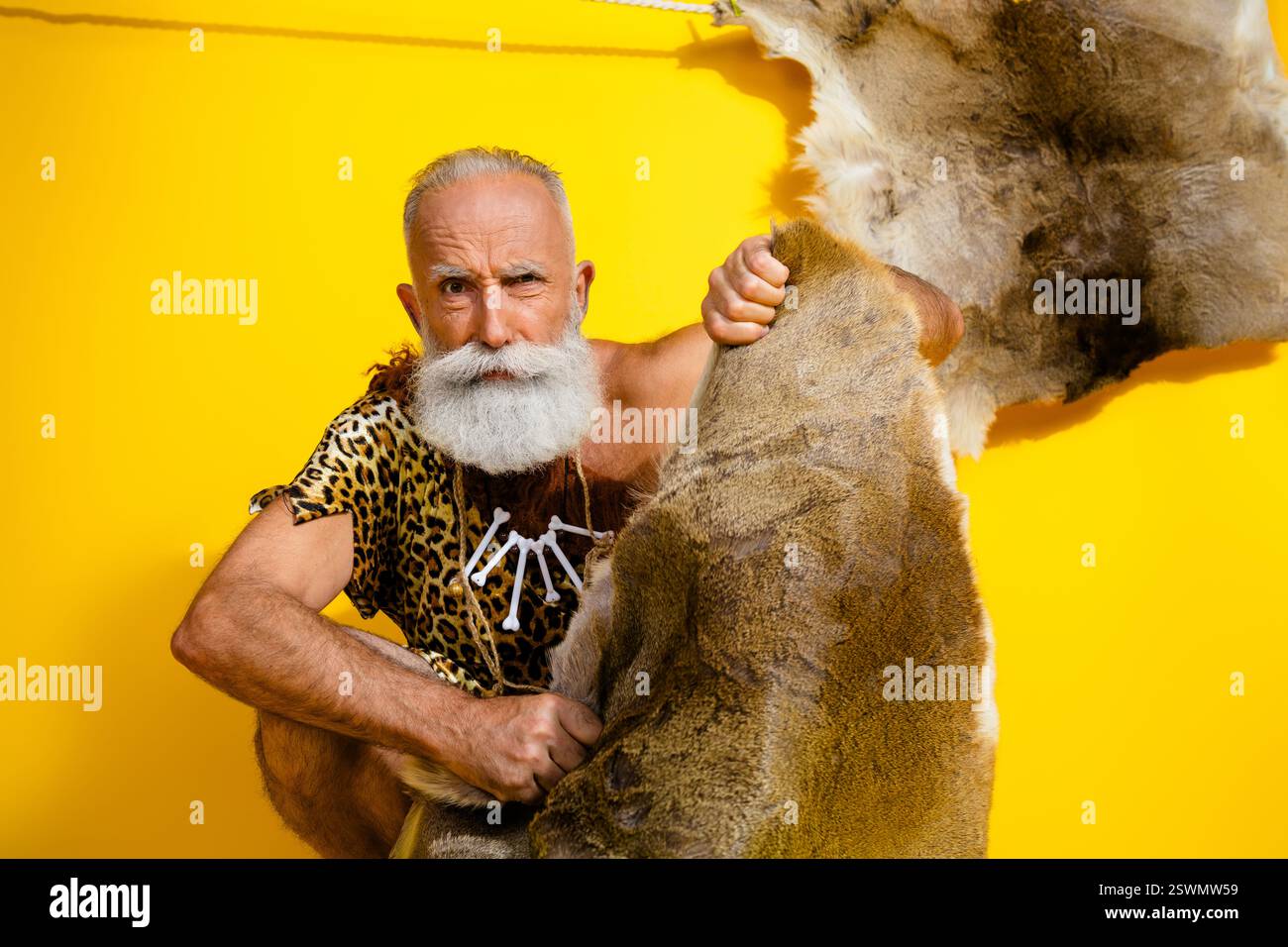 Photo of handsome serious neanderthal guy wear leoprad skin holding ...