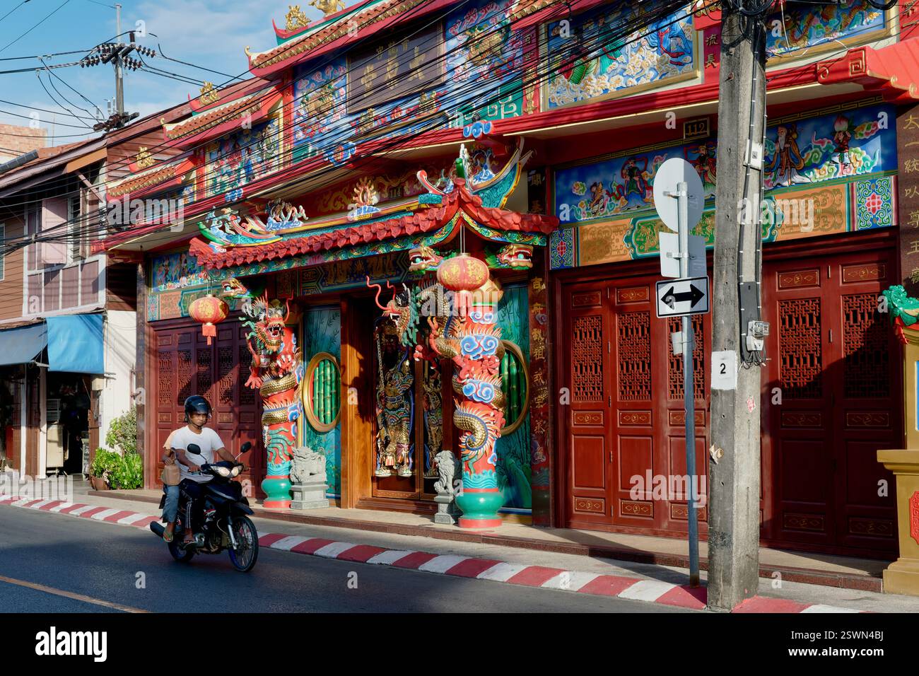 A motorcyclist passing the ornately decorated Chinese-Taoist Thye Guan ...
