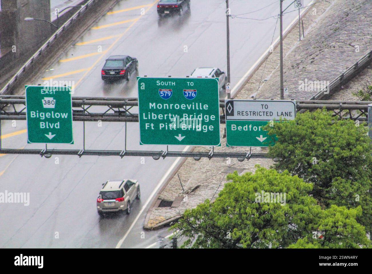 Rainy day traffic signs guide vehicles on a busy highway in Pittsburgh ...