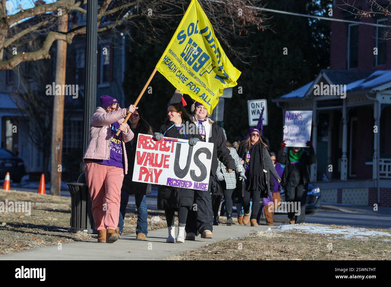 Striking Geisinger nurses carry placards as they march near the ...
