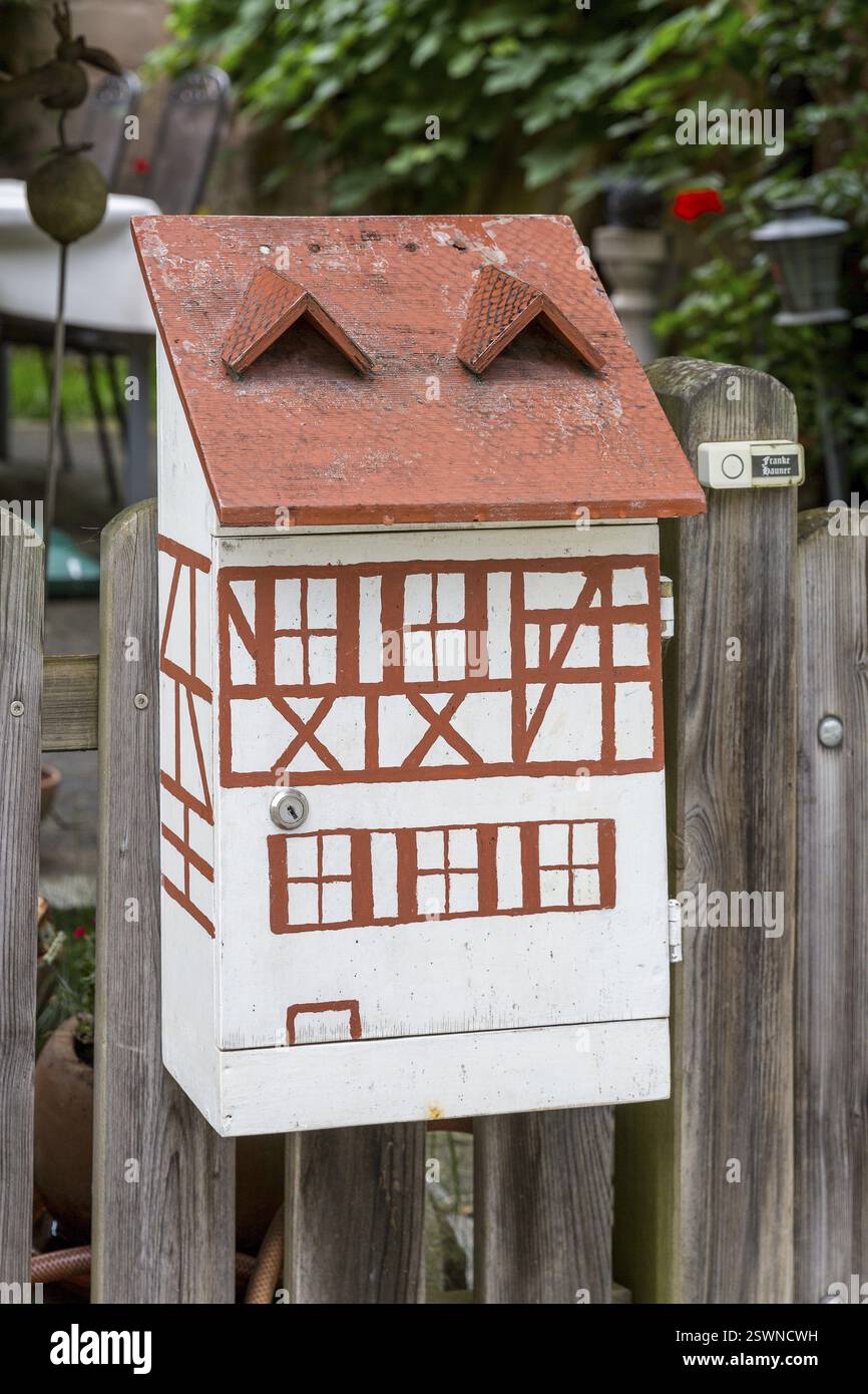 Creative wooden letterbox, painted like a half-timbered house, on a ...