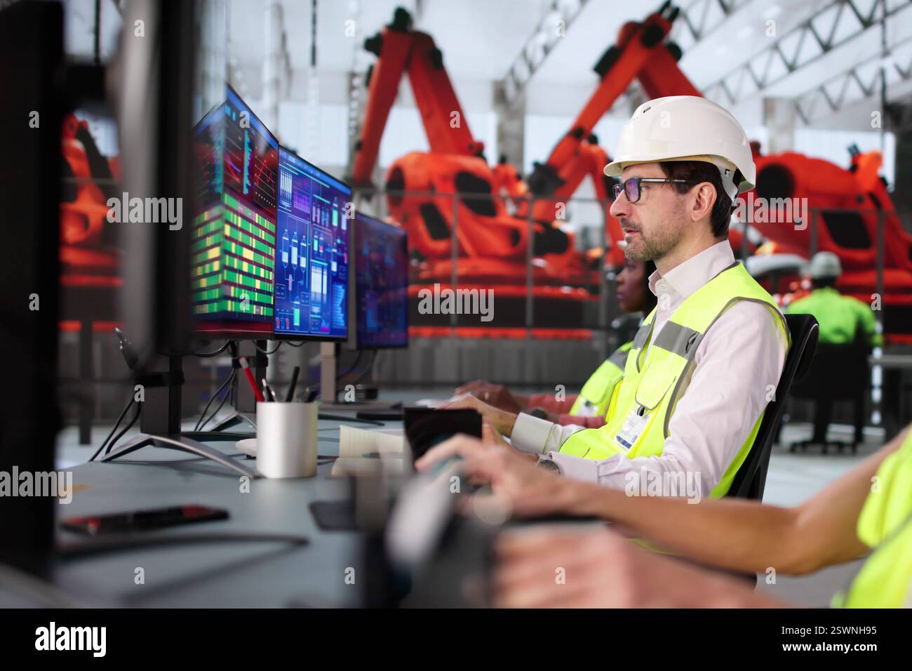 Diverse team in automotive car factory using SCADA system for ...