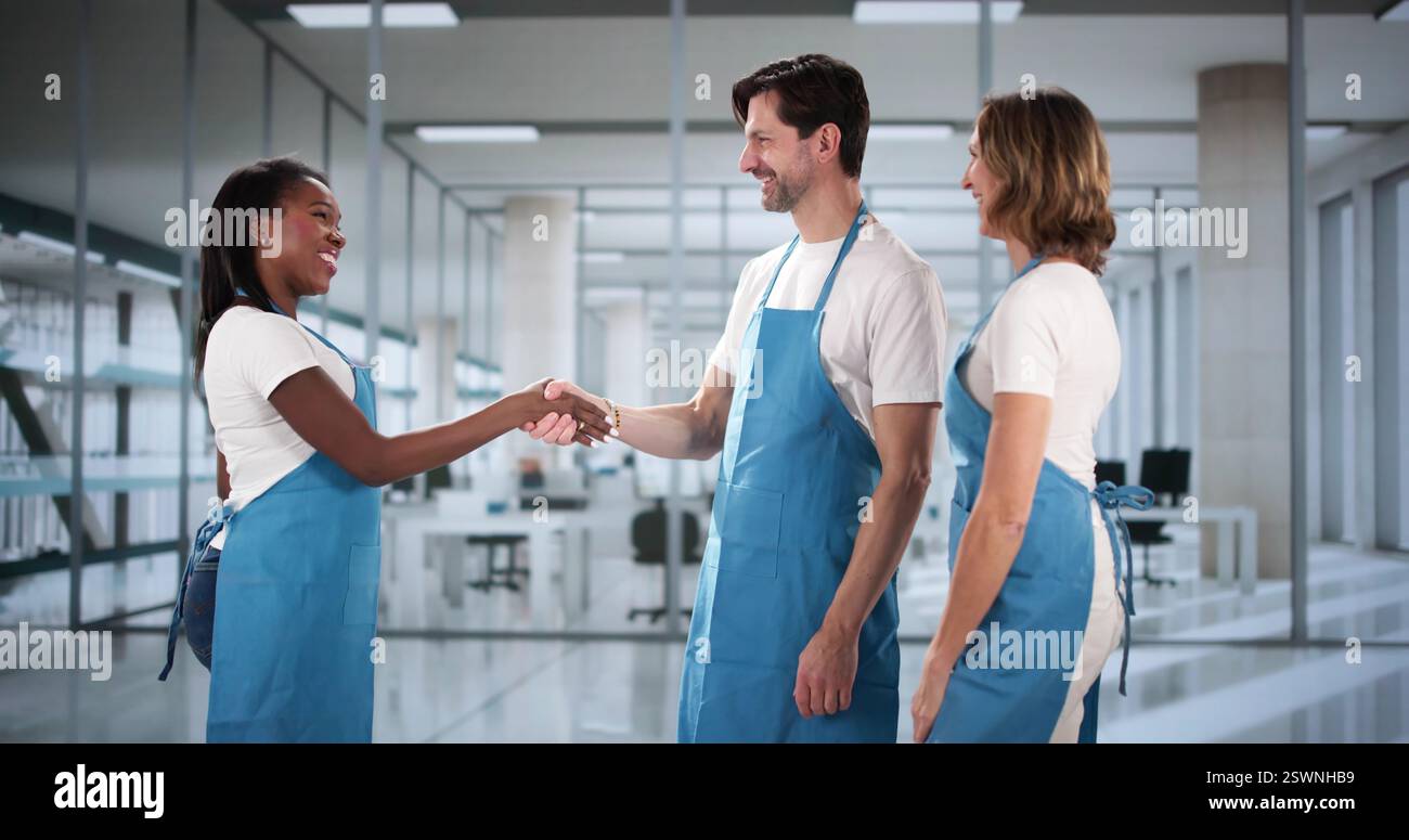 New commercial janitor greets diverse cleaning staff with handshake ...