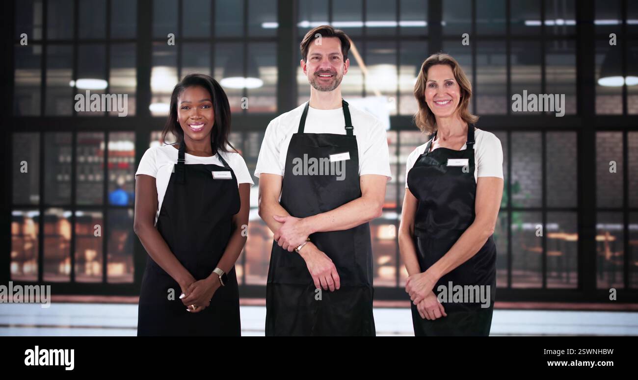Smiling server and manager pose for restaurant portrait in uniform ...