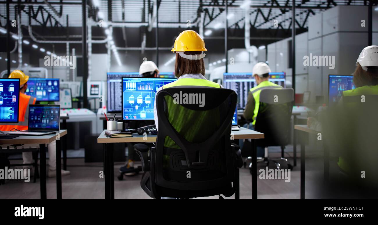 Modern young person using SCADA automation software at factory desktop ...