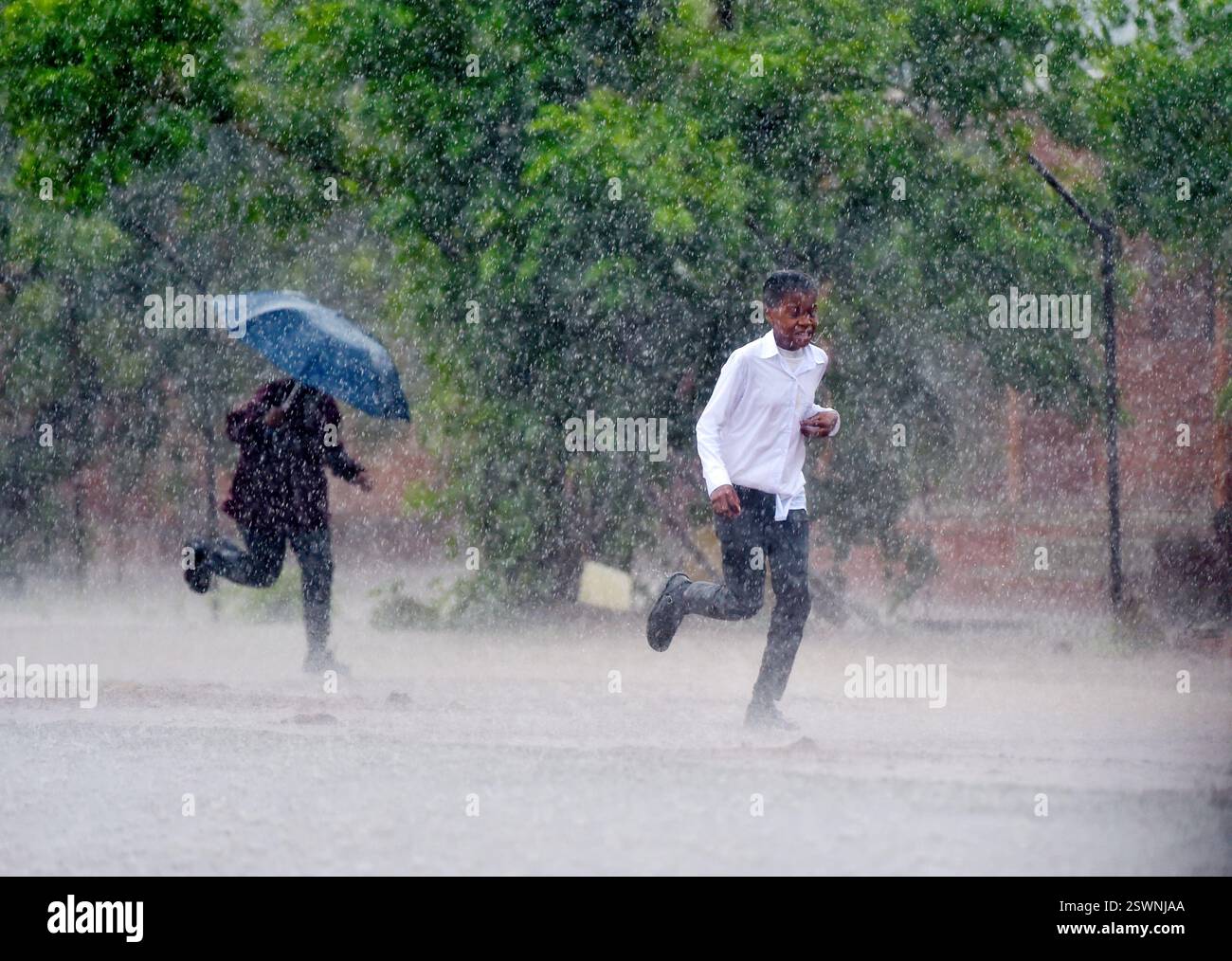 Gaborone, Botswana. 19th Feb, 2025. Students run amid heavy rain in ...