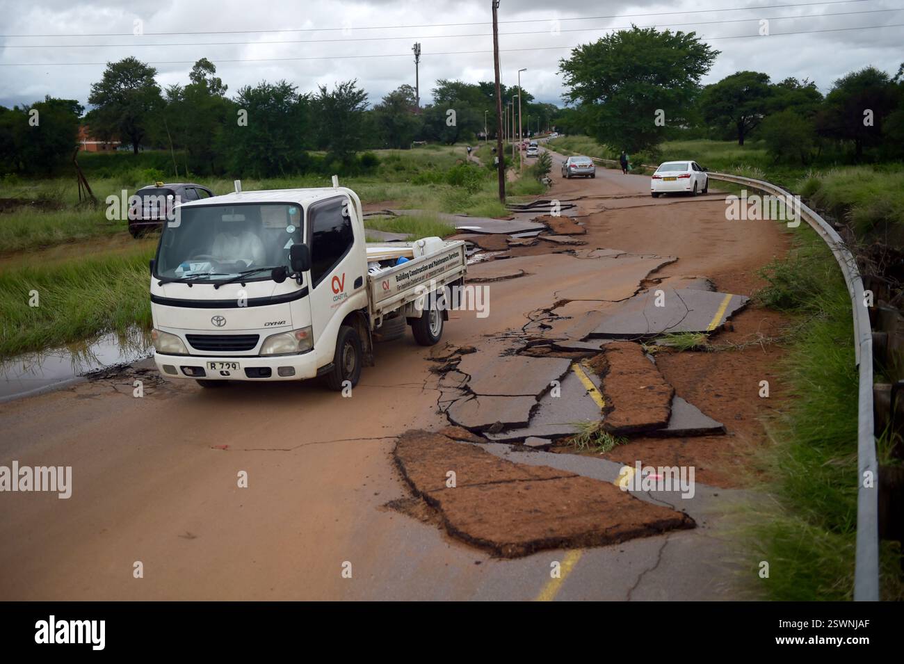 Gaborone, Botswana. 21st Feb, 2025. Vehicles move on a damaged road in ...