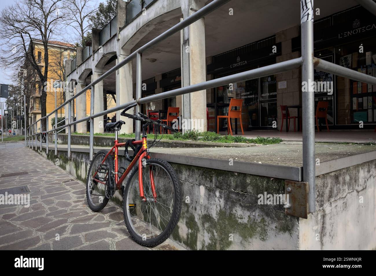 Porch of a condominium with chairs of a bar seen from the pavement ...