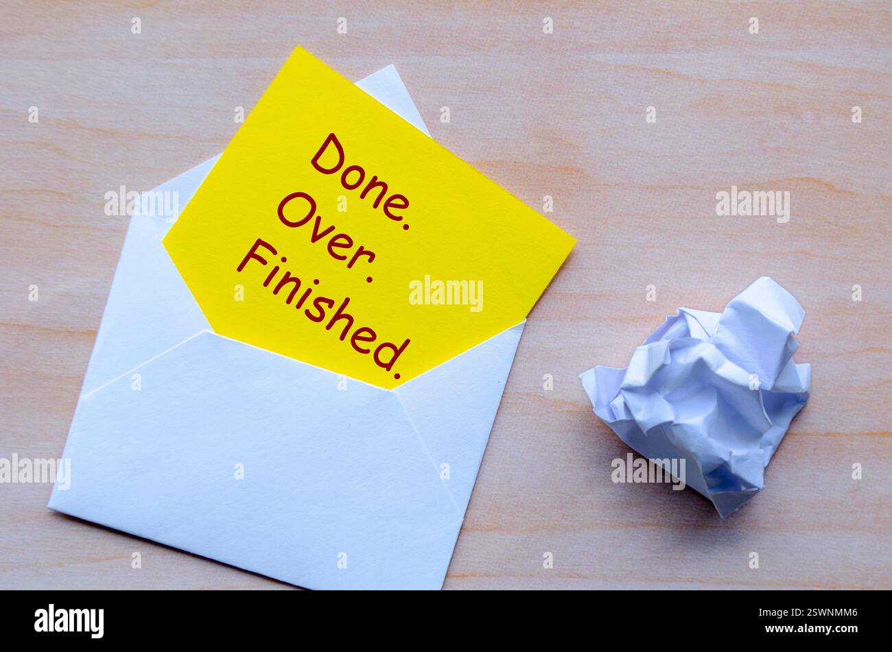 Top view of Done, Over and Finished text on yellow paper in an envelope ...