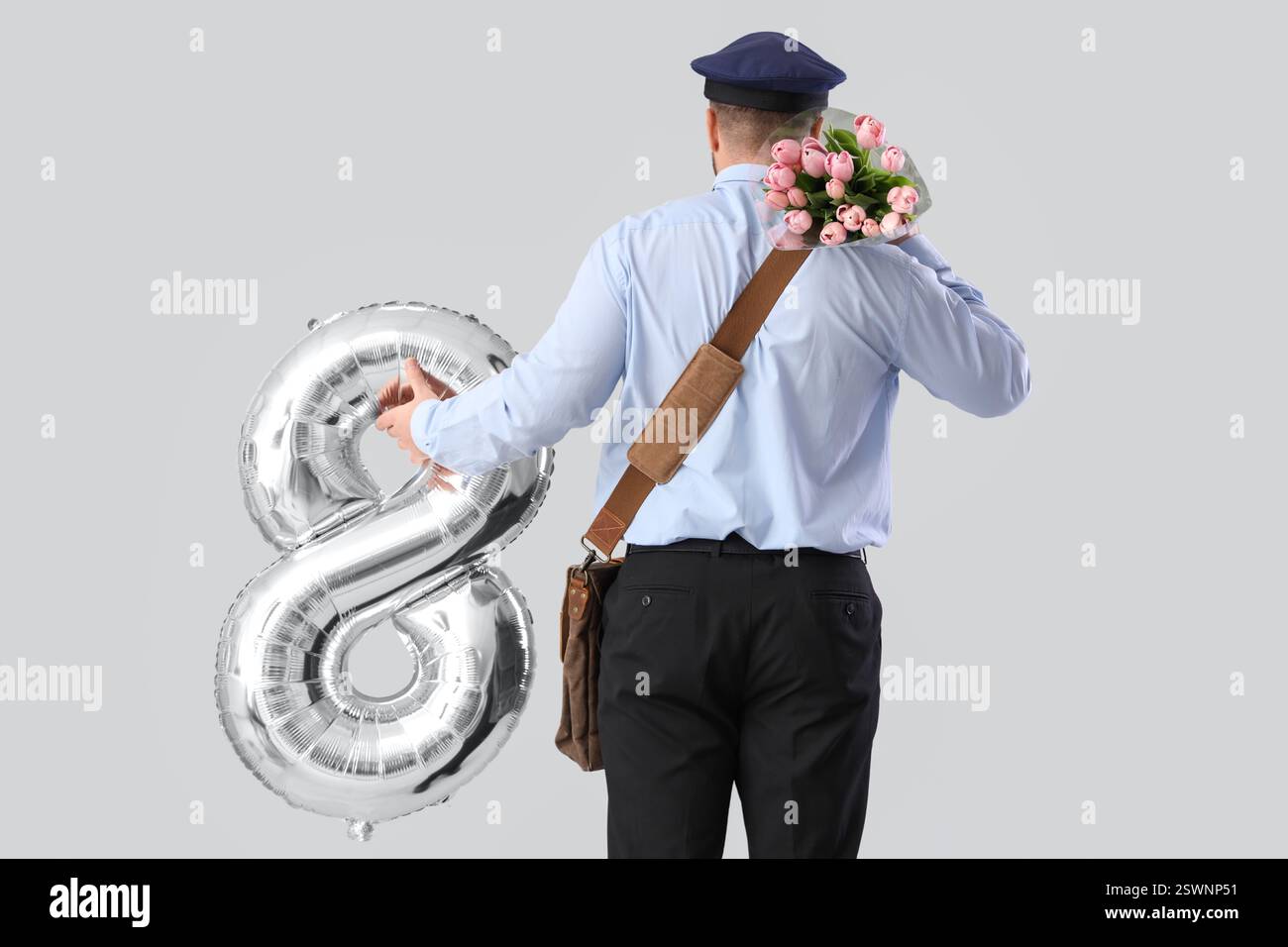 Handsome postman with tulips and balloon in shape of figure 8 on light ...