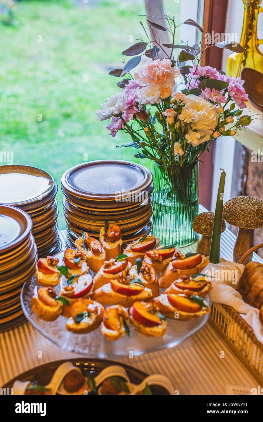 An elegant table setting featuring appetizers and flowers by a sunlit ...