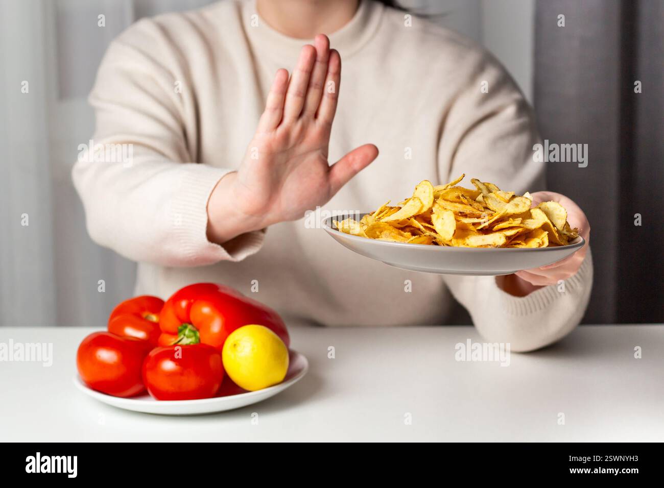 Closeup of woman making stop sign to refuse fried chips for dieting and ...