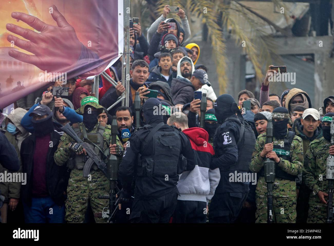 Onlookers watch as Israeli hostage Tal Shoham is escorted by Hamas ...