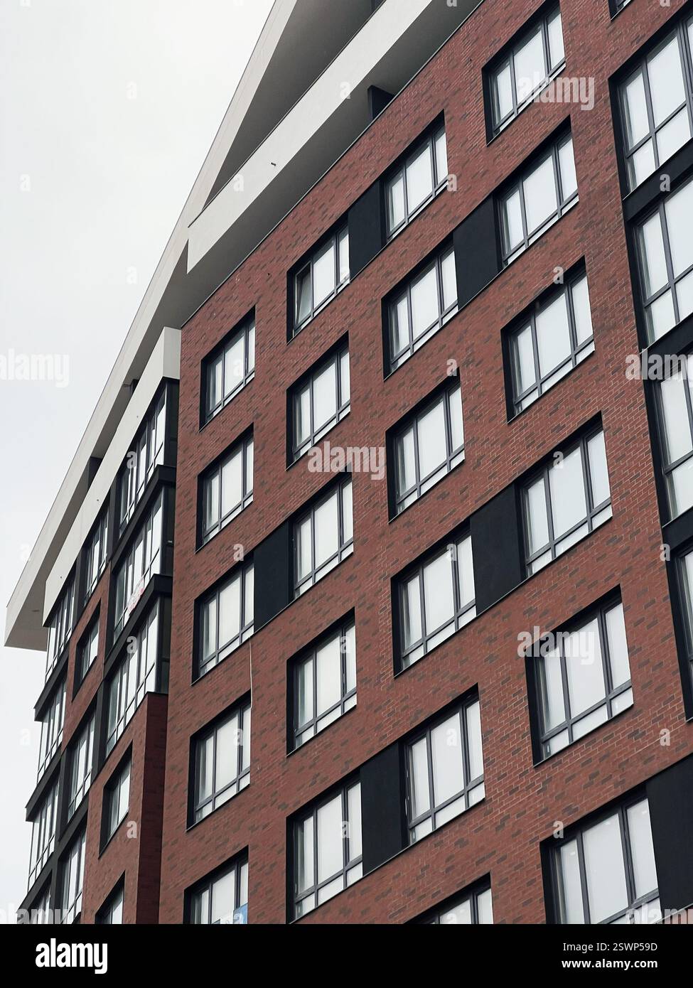 Contemporary brick apartment building with angled windows and ...