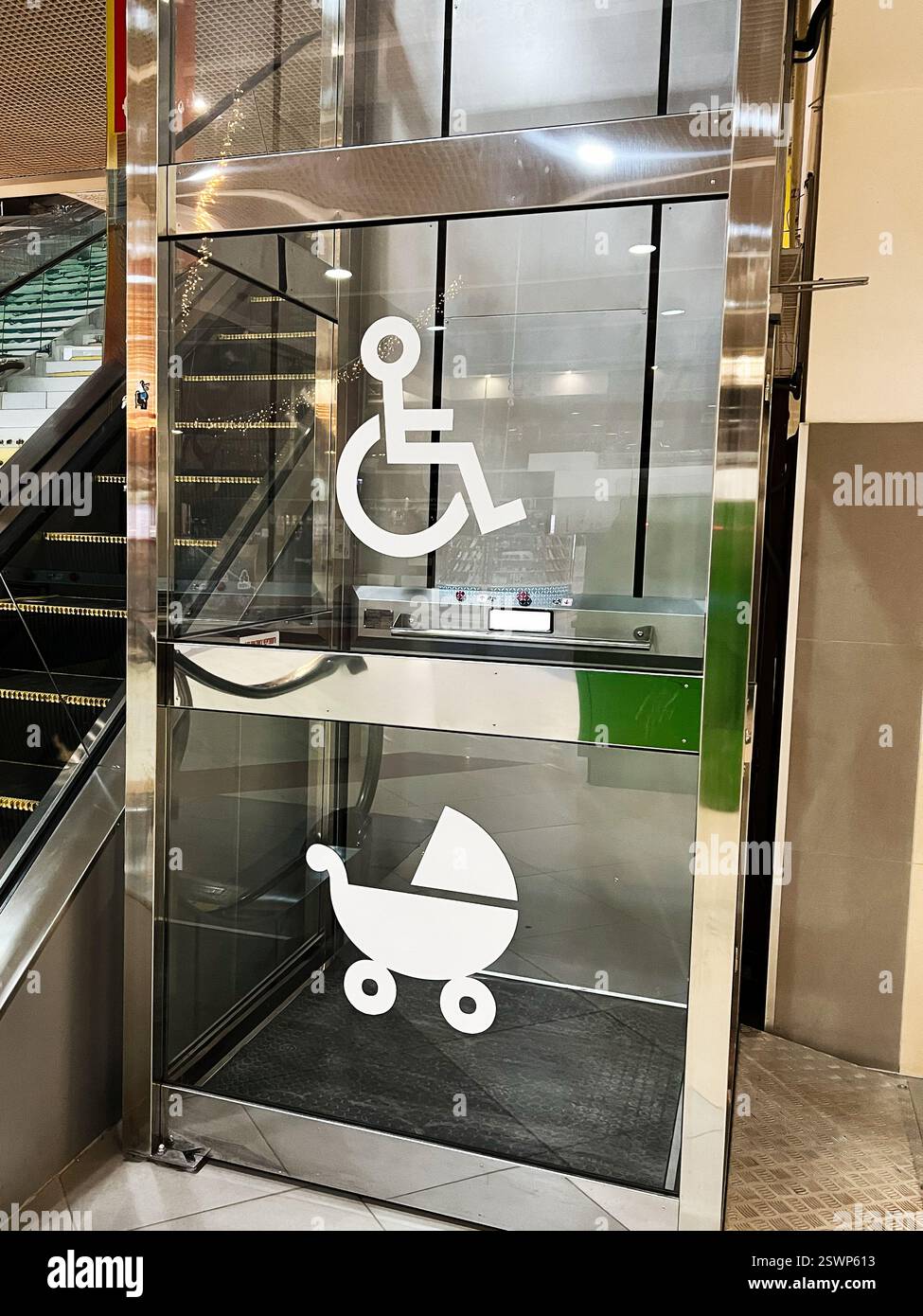 Public elevator marked with accessibility signs for wheelchairs and ...