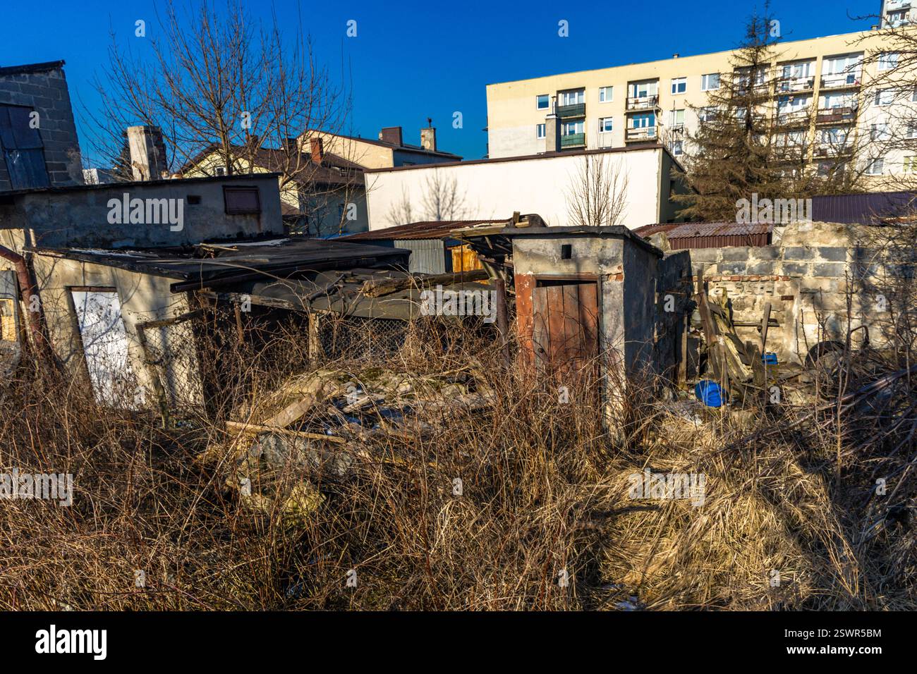 Old abandoned buildings in the center of a modern housing estate ...